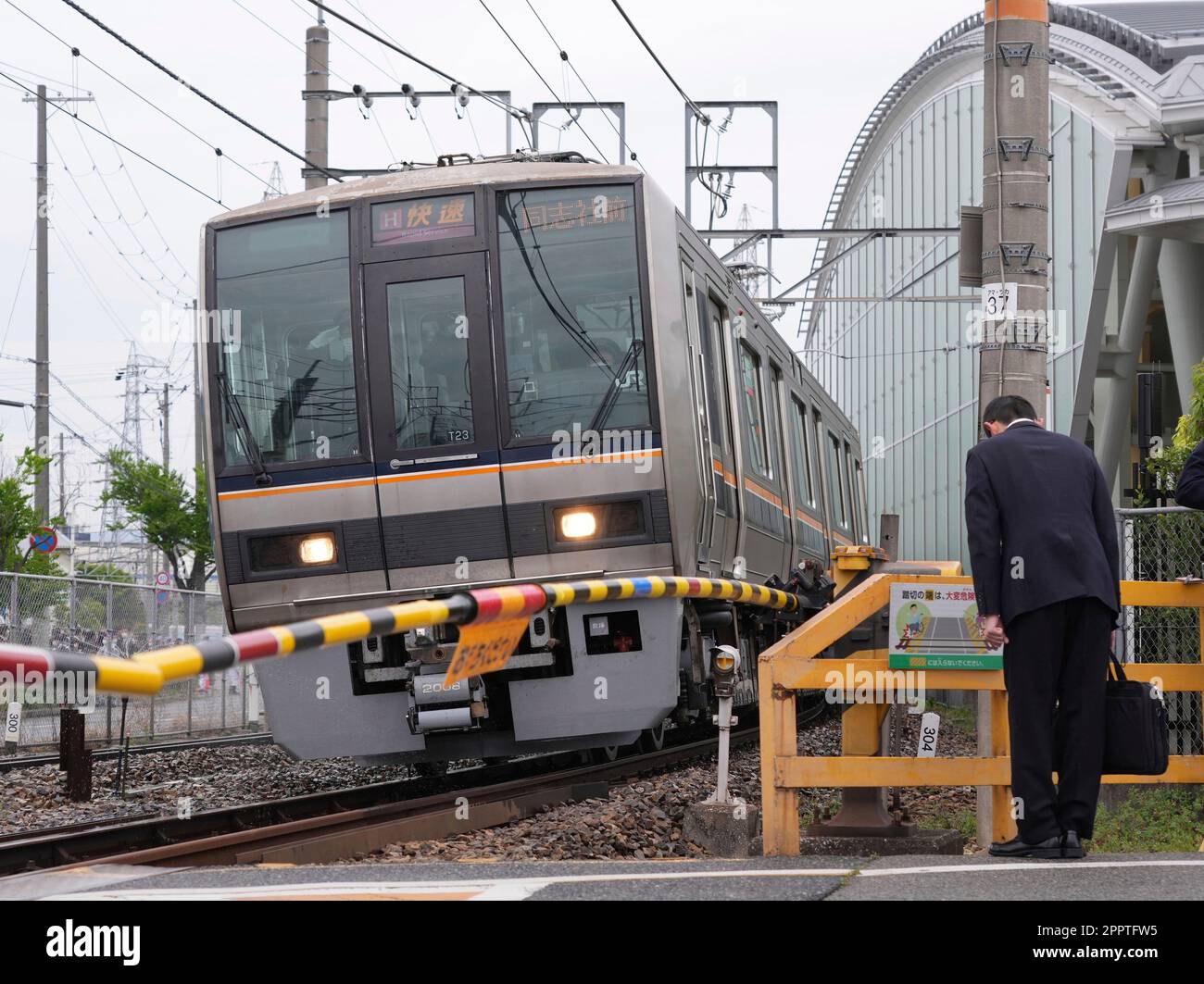 A man mourns for victims while a train is passing near the site of the derailment accident in ...