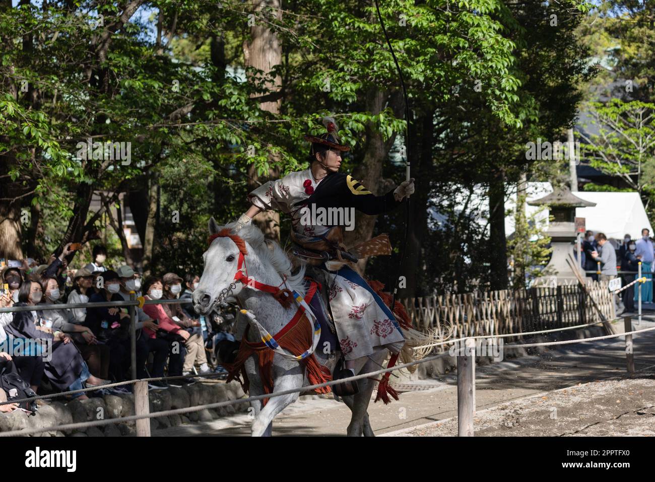 Yabusame (Japanese horseback archery) archer shoots an arrow on target ...