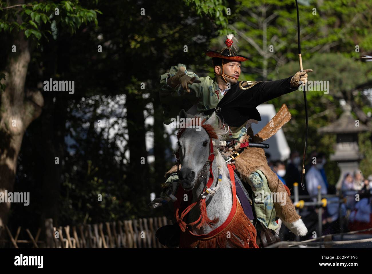 Yabusame (Japanese horseback archery) archer shoots an arrow on target ...