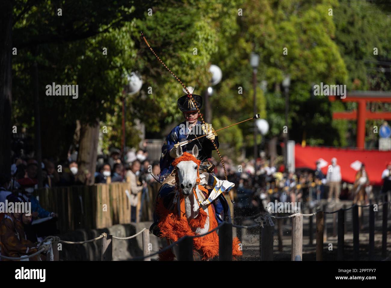 Yabusame (Japanese horseback archery) archer prepares his arrow to ...