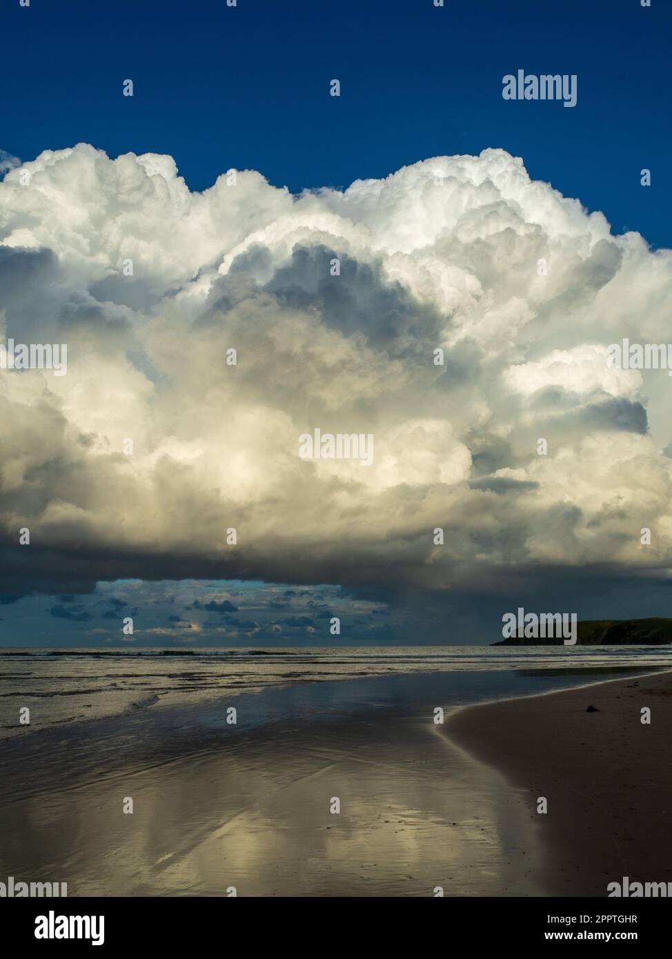 Dramatic low hanging cumulonimbus cloud hovering over the beach casting ...