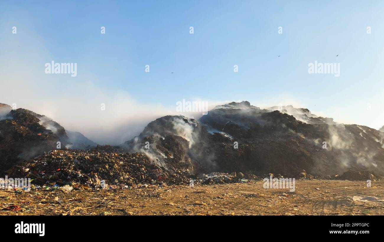 Burning pile of garbage at dump ground or landfill releasing toxic ...