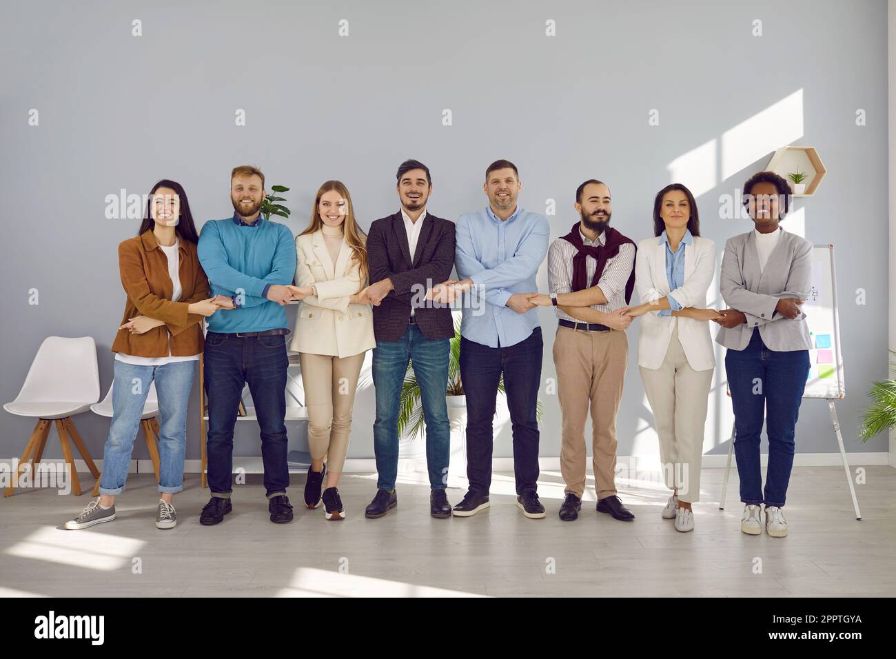 Happy multiethnic business people group standing holding hands, multi ethnic corporate team ...