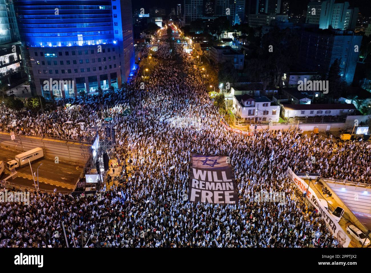 Tens of thousands of Israelis wave their national flag during a protest ...
