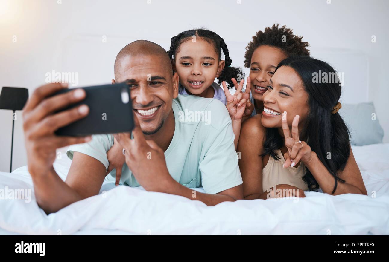 Selfie smile, family and peace sign in bedroom, bonding and relaxing ...