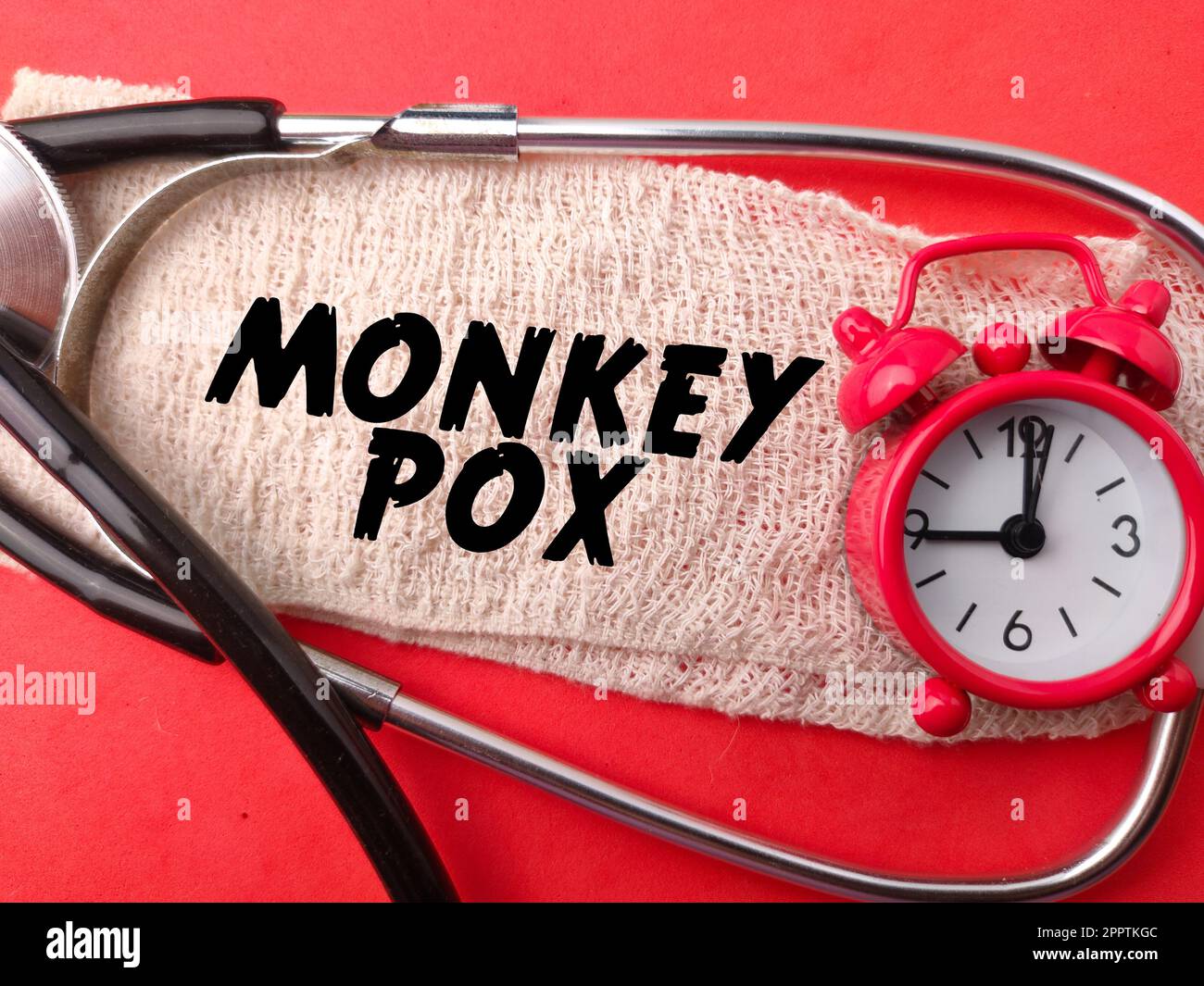 Stethoscope and clock with the word MONKEY POX on red background Stock ...