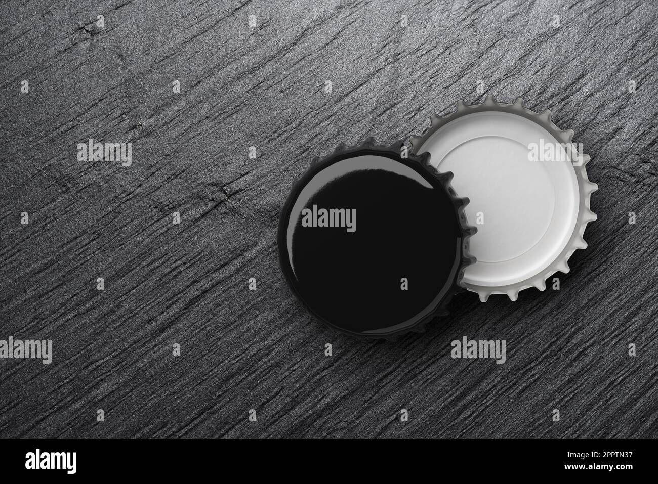 Black beer caps on dark slate background or texture. Mock up design ...