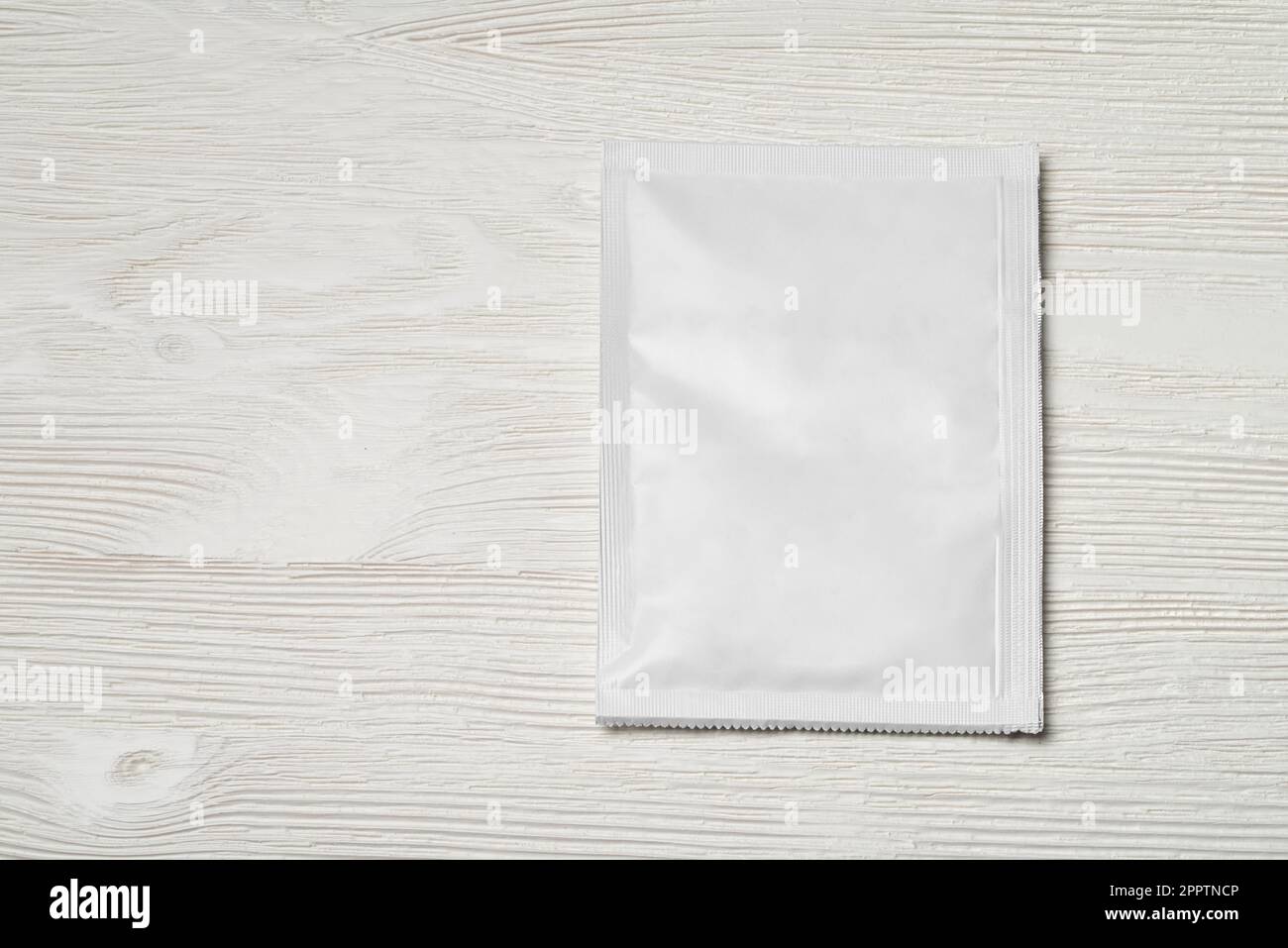 White blank paper sachet packet on wood table. Mock-up template for ...