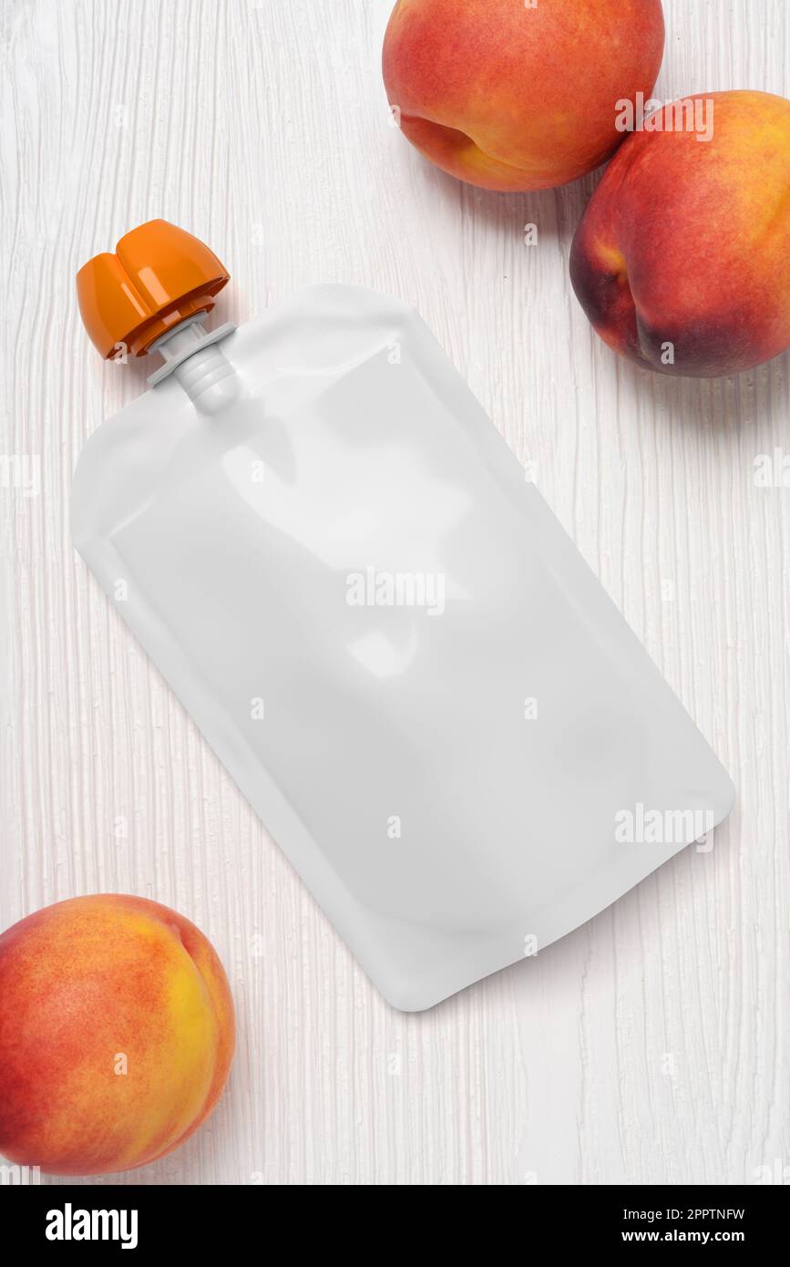 White empty plastic pouche for baby food, fruit puree on wood table ...