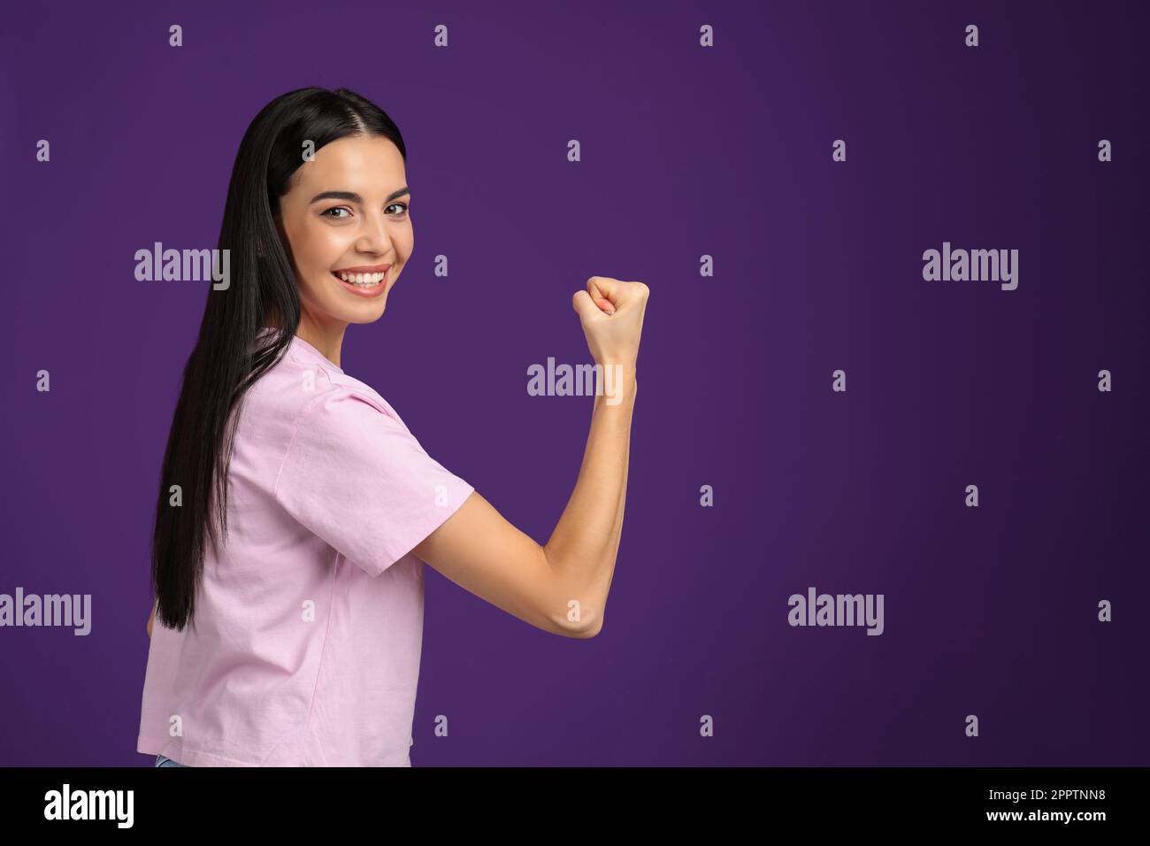 Strong woman as symbol of girl power on purple background, space for ...