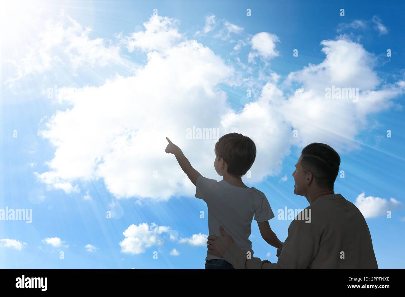 Godparent with child pointing at blue sky with white clouds Stock Photo ...