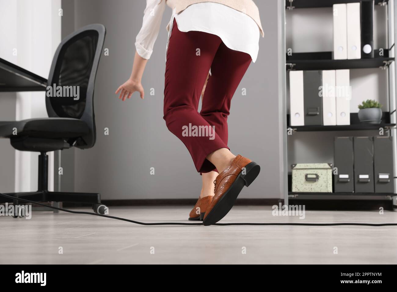 Woman tripping over cable in office, closeup Stock Photo - Alamy