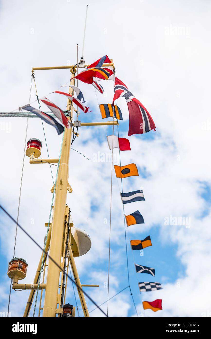 Signal flag flying from a yellow ship mast Stock Photo - Alamy