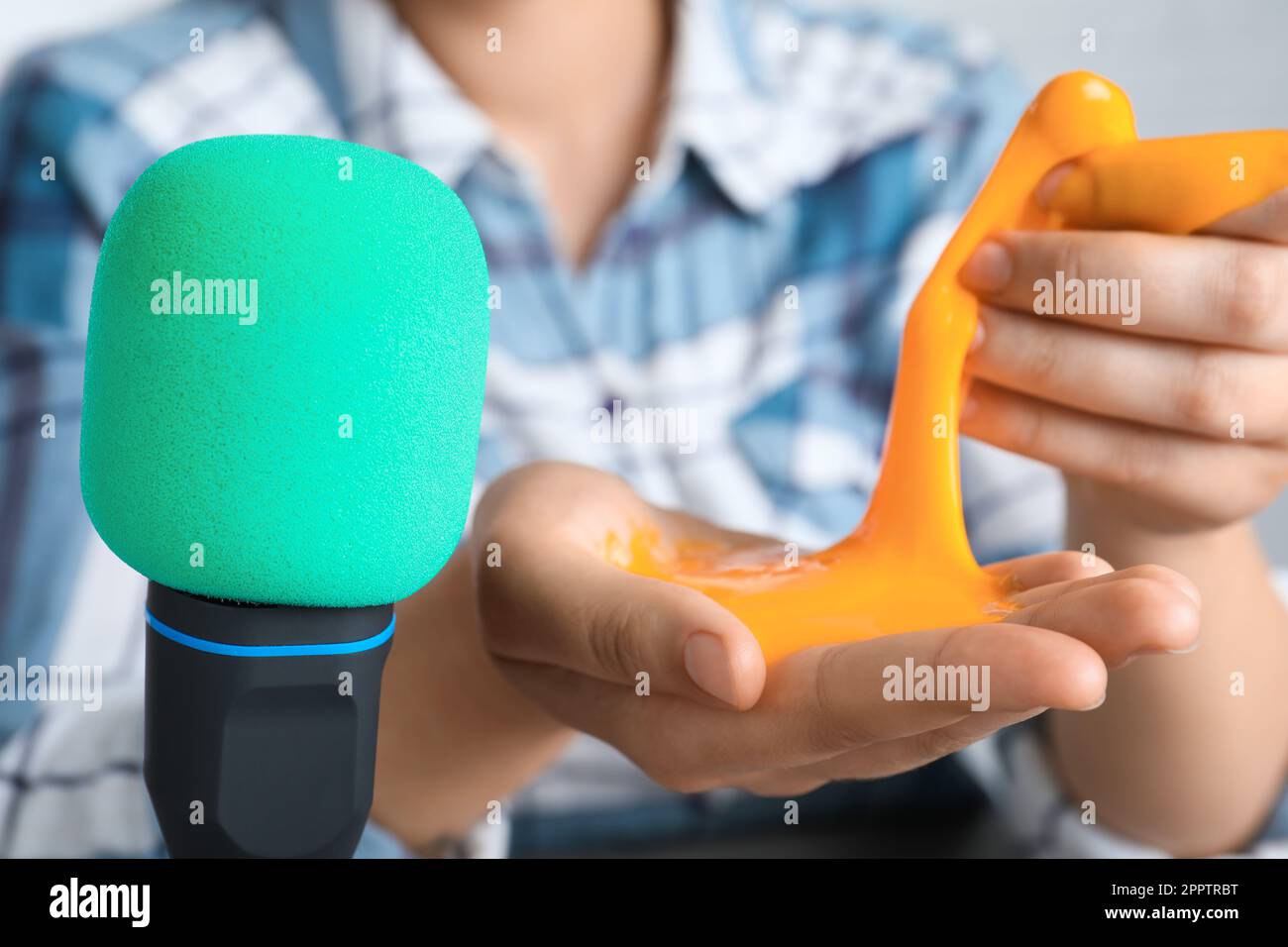 Woman making ASMR sounds with microphone and bright slime, closeup ...
