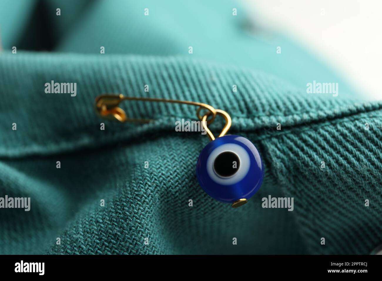 Evil eye safety pin on denim clothing, closeup Stock Photo - Alamy