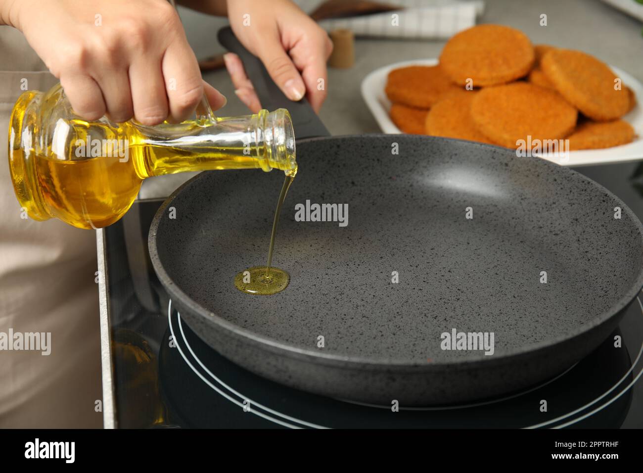 Woman adding oil on frying pan, closeup. Cooking breaded cutlets Stock ...