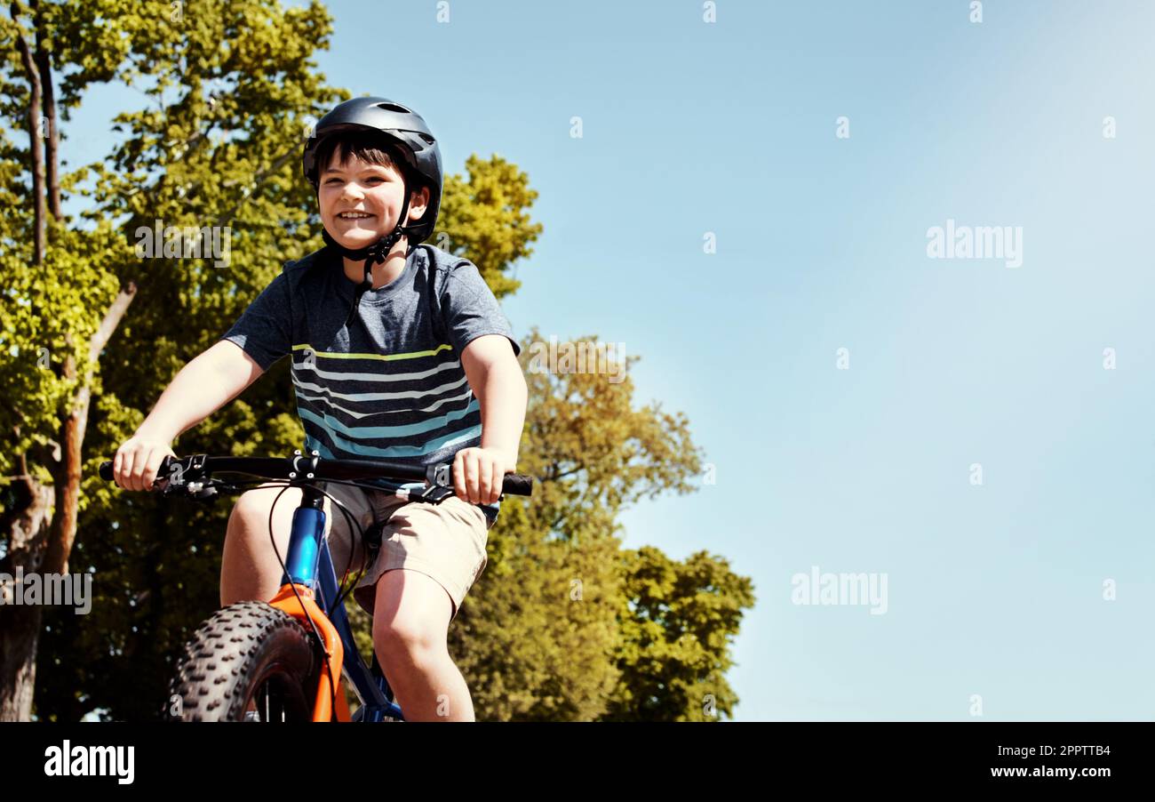 Cycling around the block. a young boy riding his bicycle through his ...