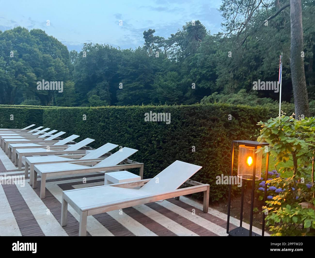 Many empty sunbeds near outdoor swimming pool at resort Stock Photo - Alamy