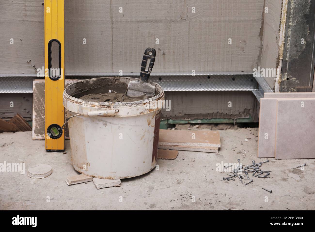 Adhesive mix, bubble level and ceramic tiles on floor indoors Stock ...