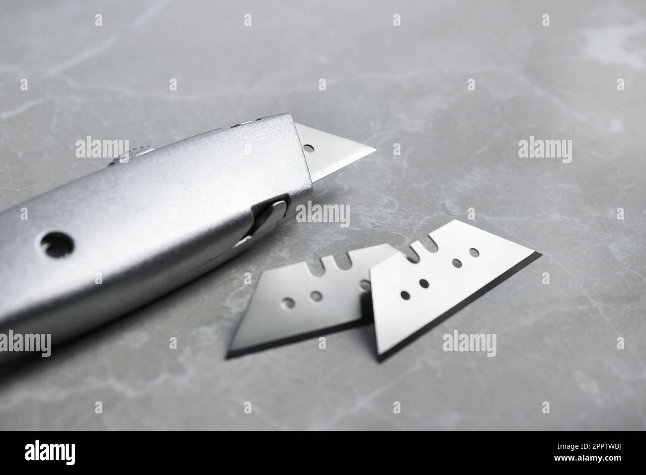 Utility knife and blades on light grey table, closeup Stock Photo - Alamy