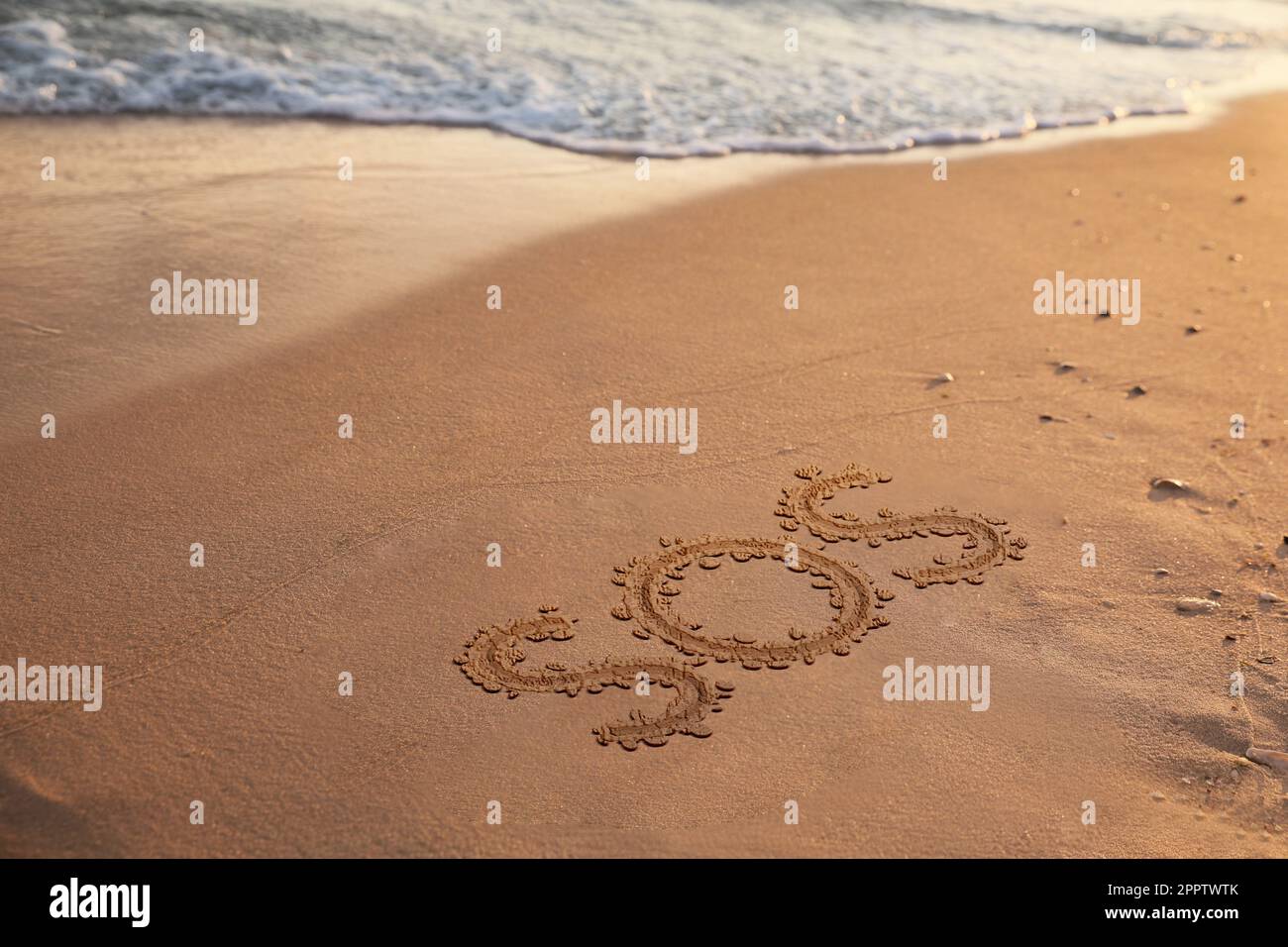 SOS message drawn on sandy beach near sea Stock Photo - Alamy