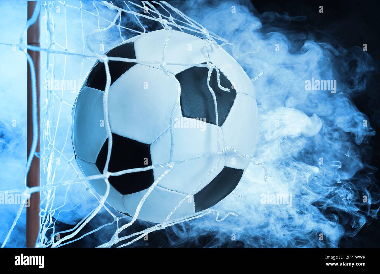 Soccer ball in net and white smoke against black background Stock Photo ...