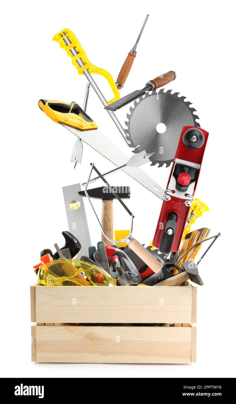 Different carpenter's tools falling into wooden box on white background ...