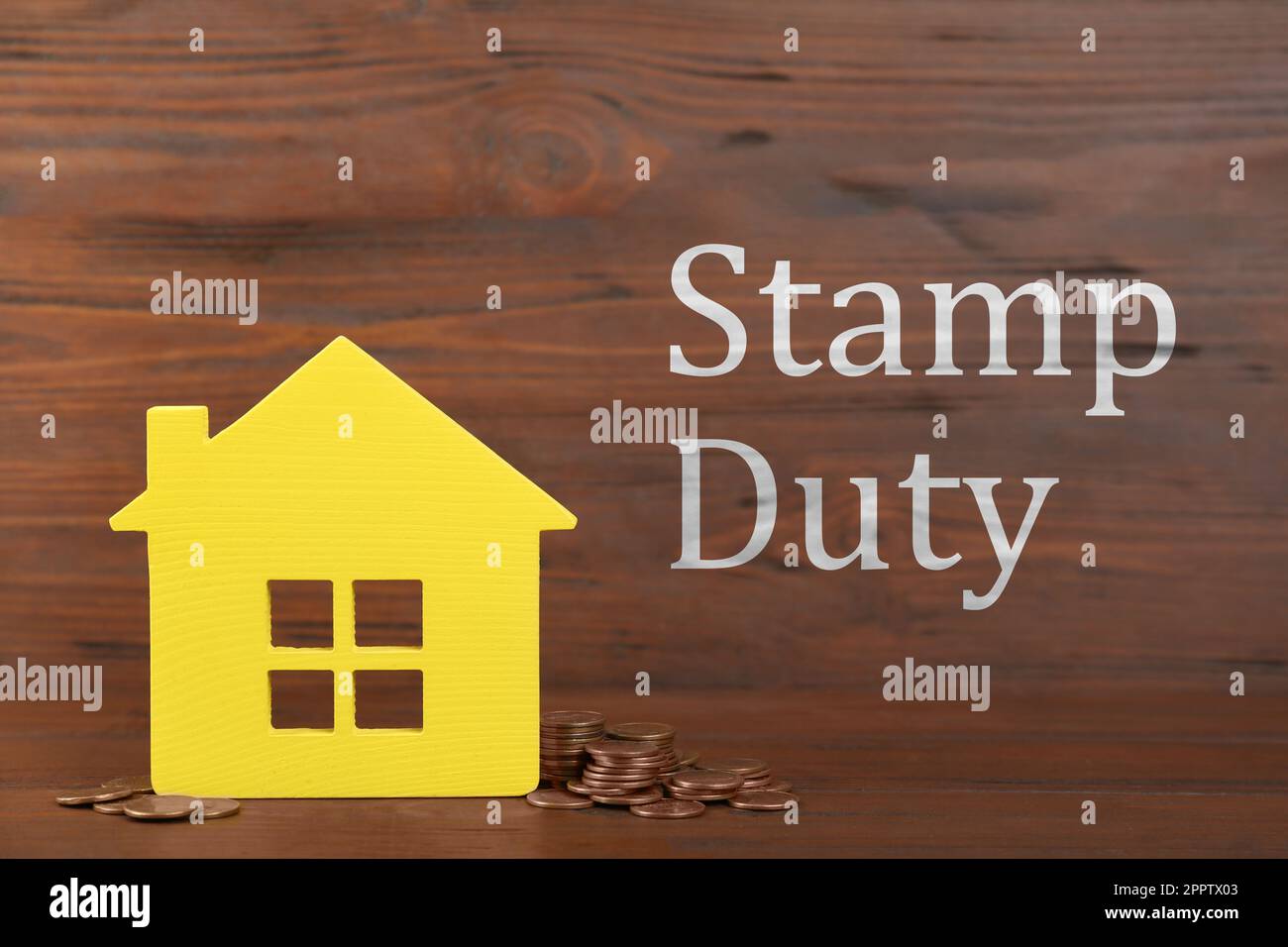 Stamp duty. House model and coins on wooden background Stock Photo - Alamy