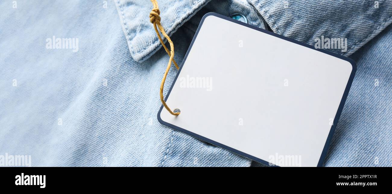 Blank tag on denim shirt, closeup view with space for text. Banner ...