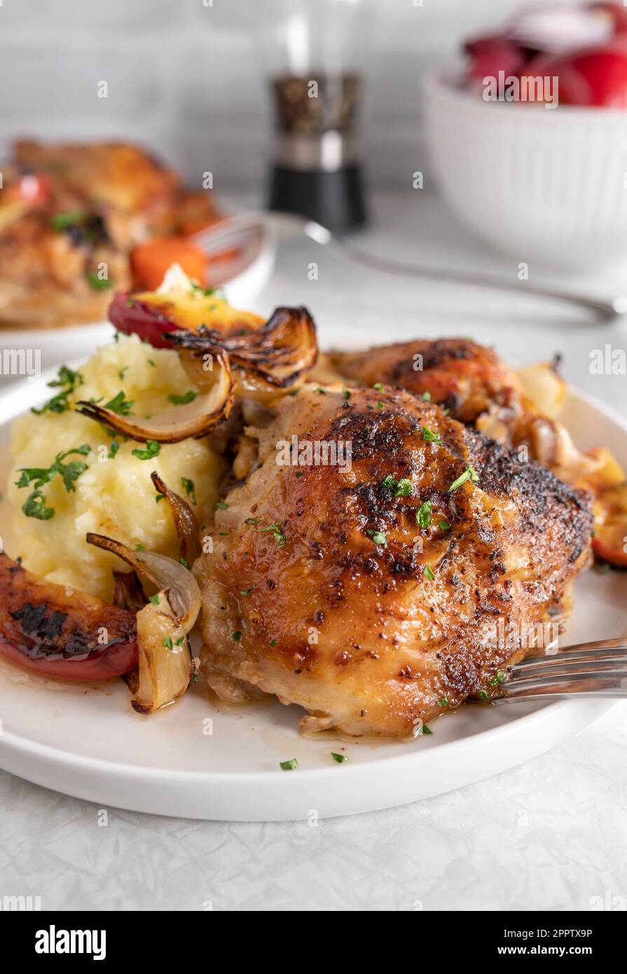 Roasted chicken shanks with mashed potatoes, roasted, onions and apples ...