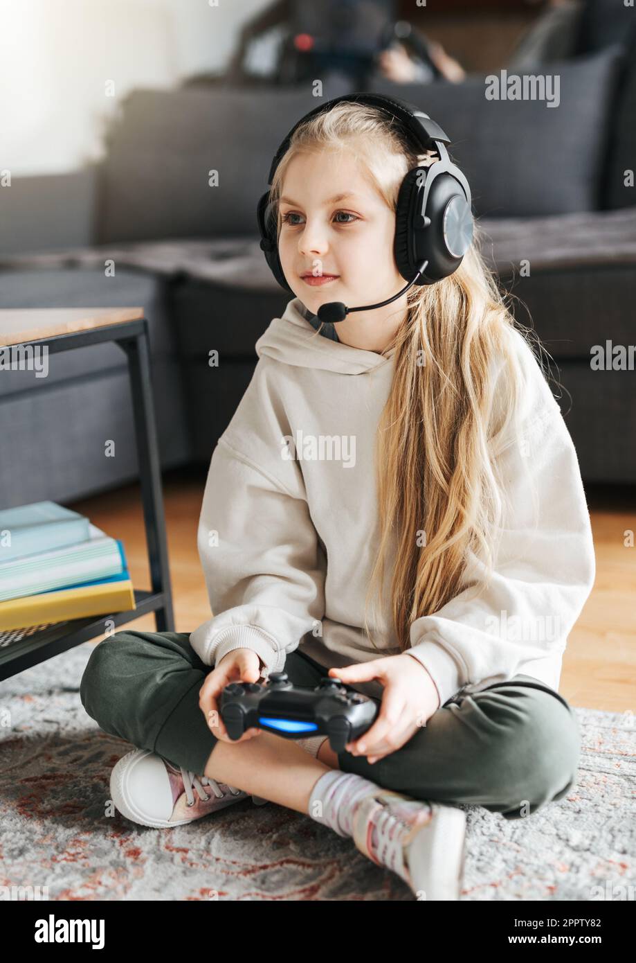 A little girl holding game controller playing video games Stock Photo ...
