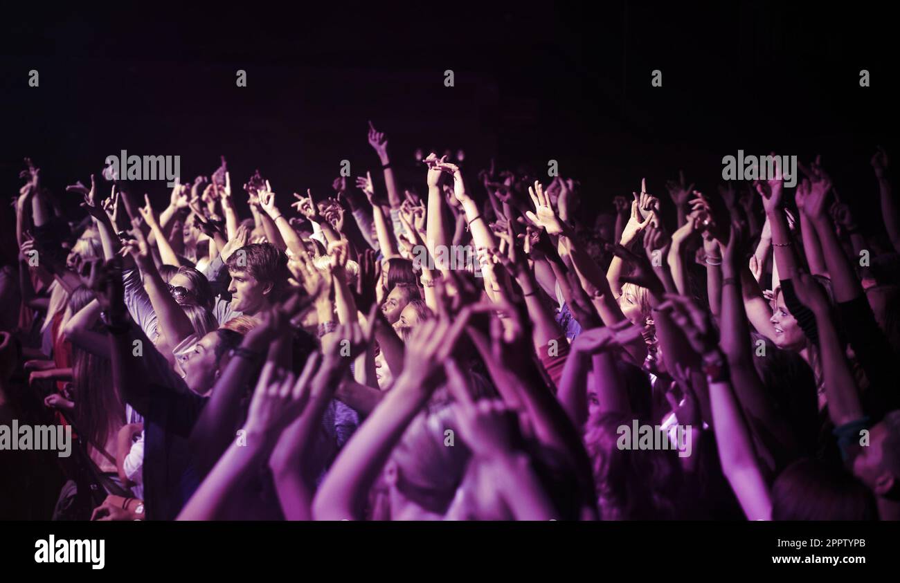 Big crowd, hands and people at music festival or concert, neon lights ...