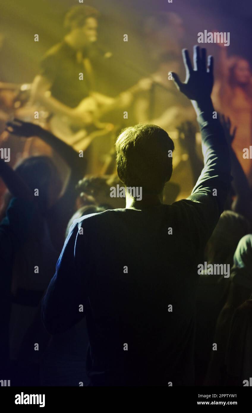 Concert, singing and people dancing to music at night performance, rock ...