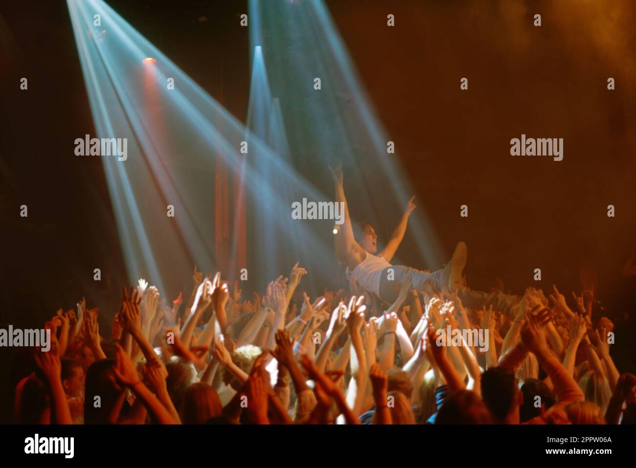 Stage dive, hands and people at music festival, neon spotlight and energy at live concert event ...