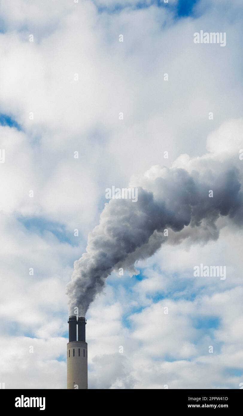 Smoke cloud emitting from factory smokestack into sky Stock Photo - Alamy