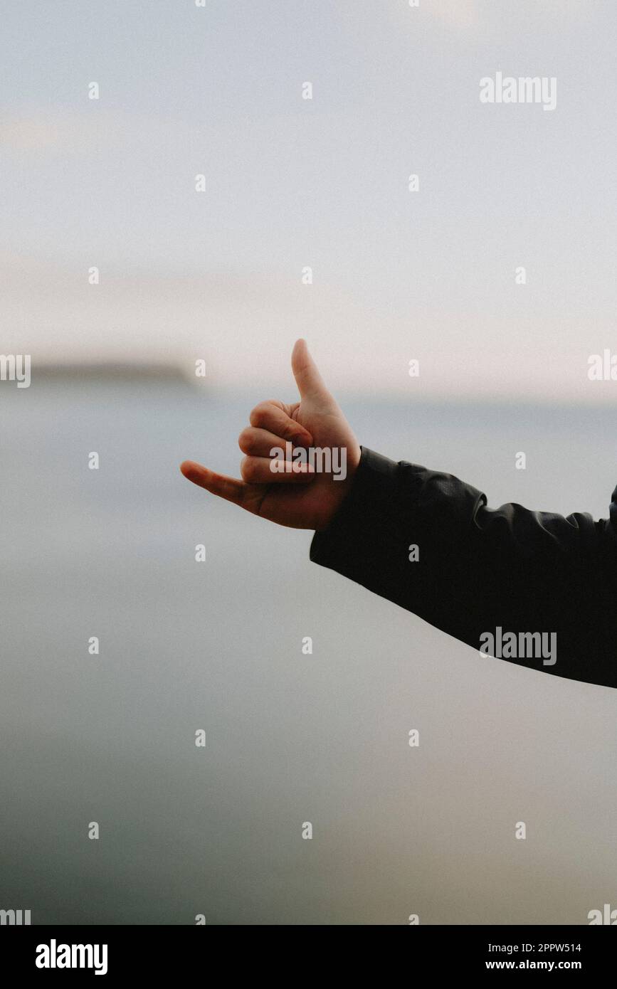 Close up hand of man gesturing shaka on beach Stock Photo - Alamy
