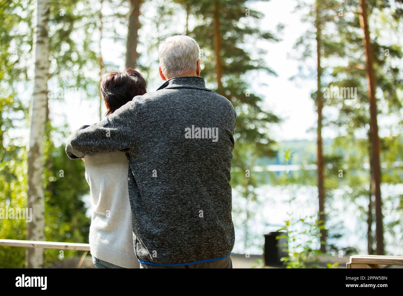 Mature Couple Standing On Porch And Hugging They Are Smiling And