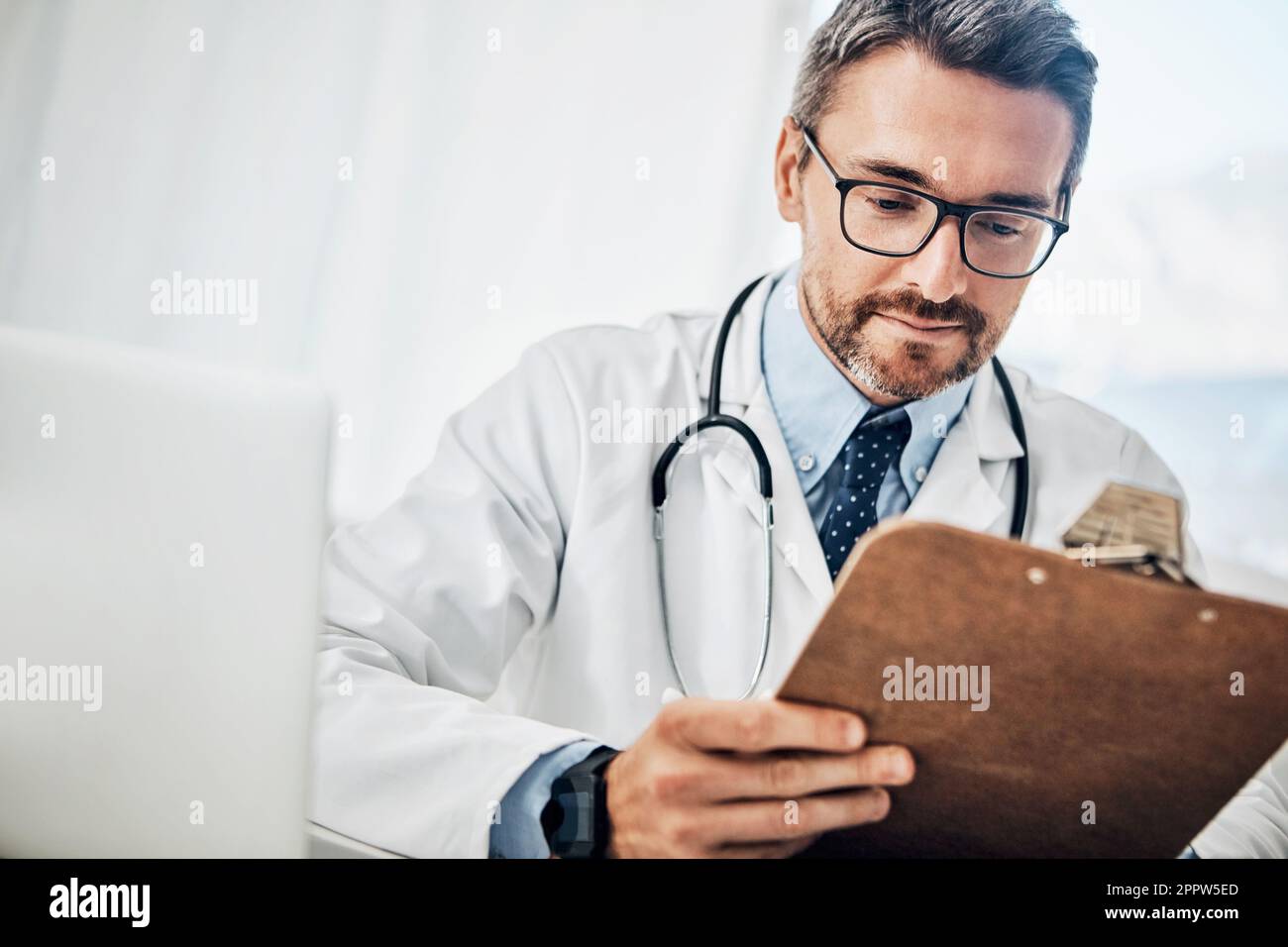 Getting to know his patient through medical records. a focussed doctor ...