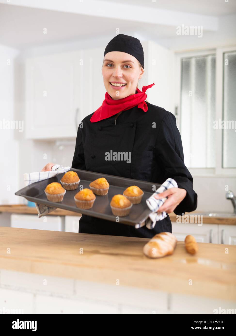 Proffesional woman in chef uniform holding sheet pan with just baked ...