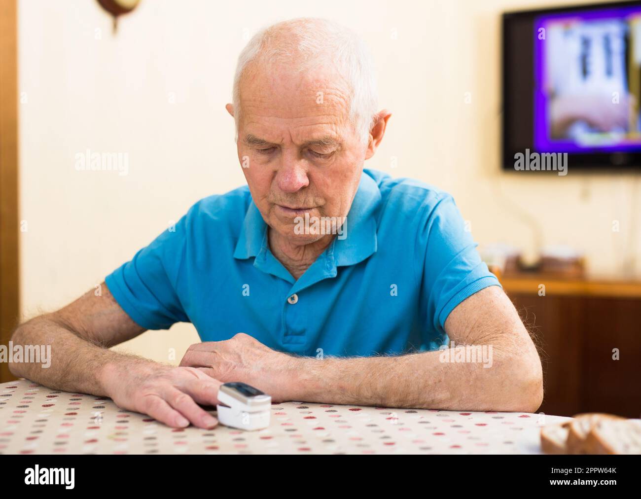 Focused worried elderly man measuring himself oxygen saturation while ...