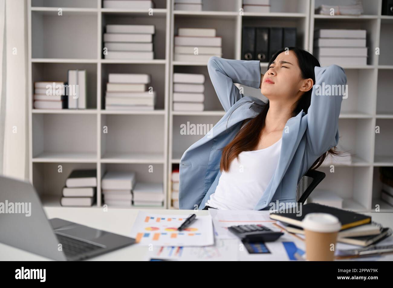 Exhausted and overworked millennial Asian businesswoman putting her ...