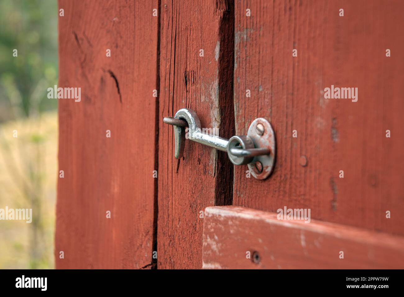 hook lock latched to bent nail on a red wood door Stock Photo - Alamy