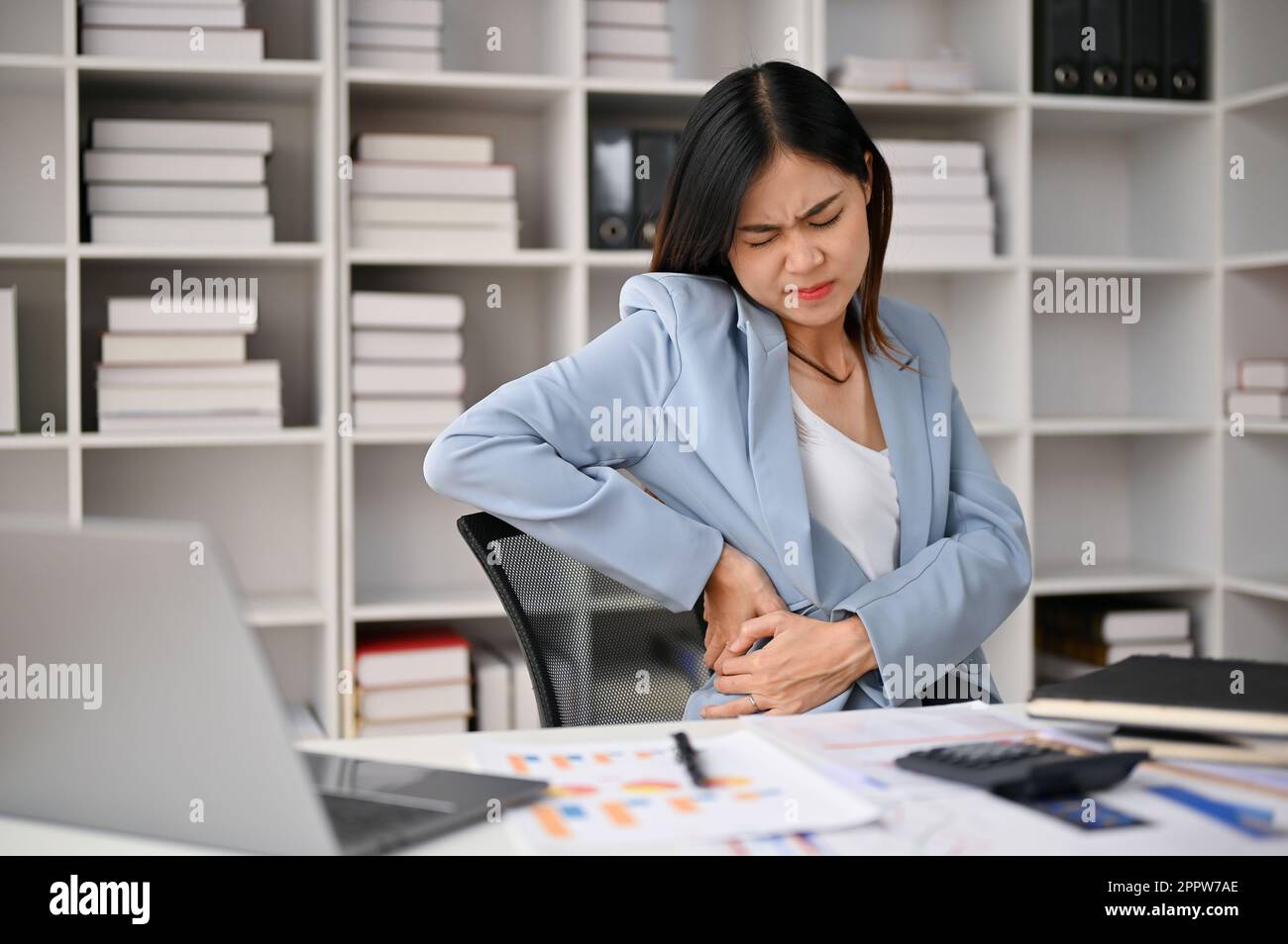 Tired and unwell millennial Asian businesswoman suffering from her ...