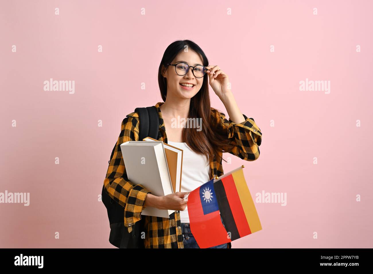 Pretty and wise young Asian female college student in a flannel shirt ...