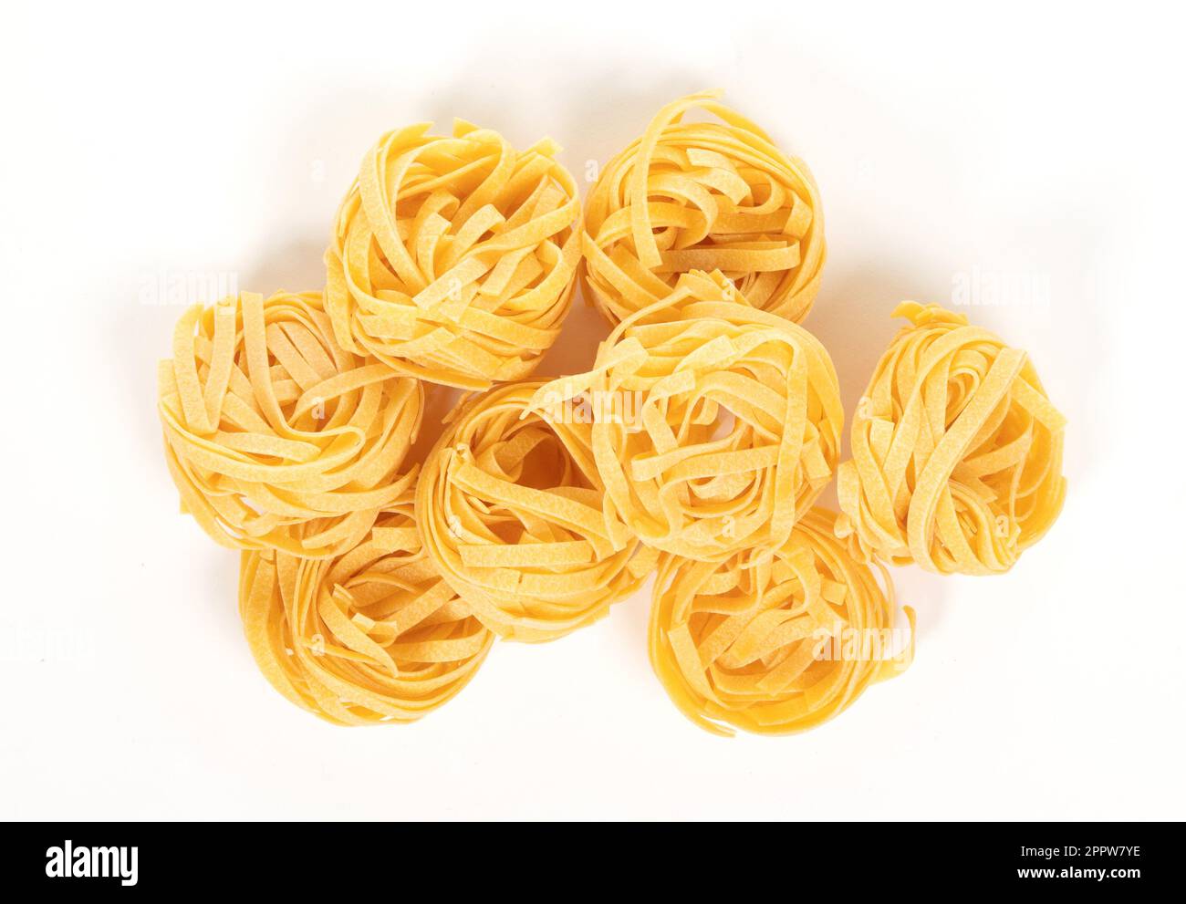 Tagliatelle pasta rolls on a white background Stock Photo - Alamy