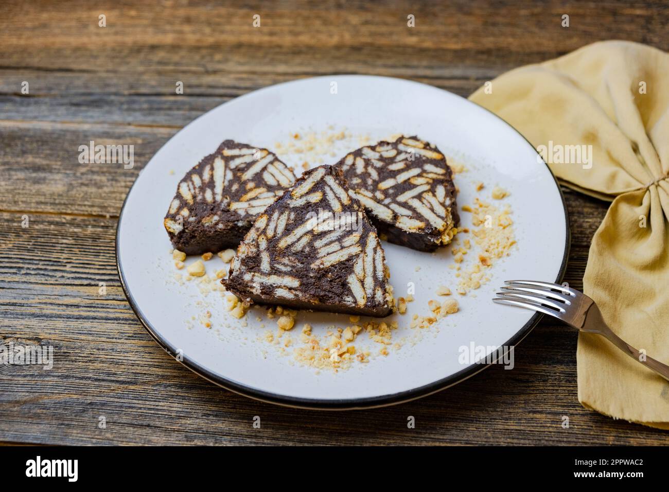 Mosaic cake with homemade chocolate and biscuits on a white plate ...