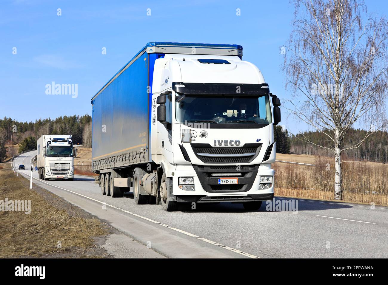 Freight transport by two white heavy trucks. Iveco NP and Volvo FH ...
