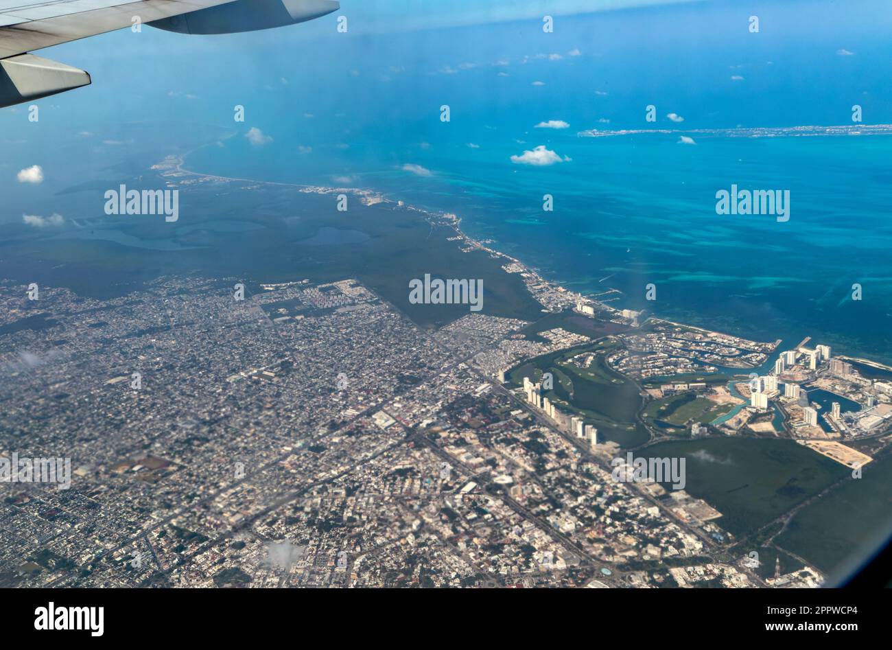 Aerial view through plane window of Caribbean coastline buildings in ...