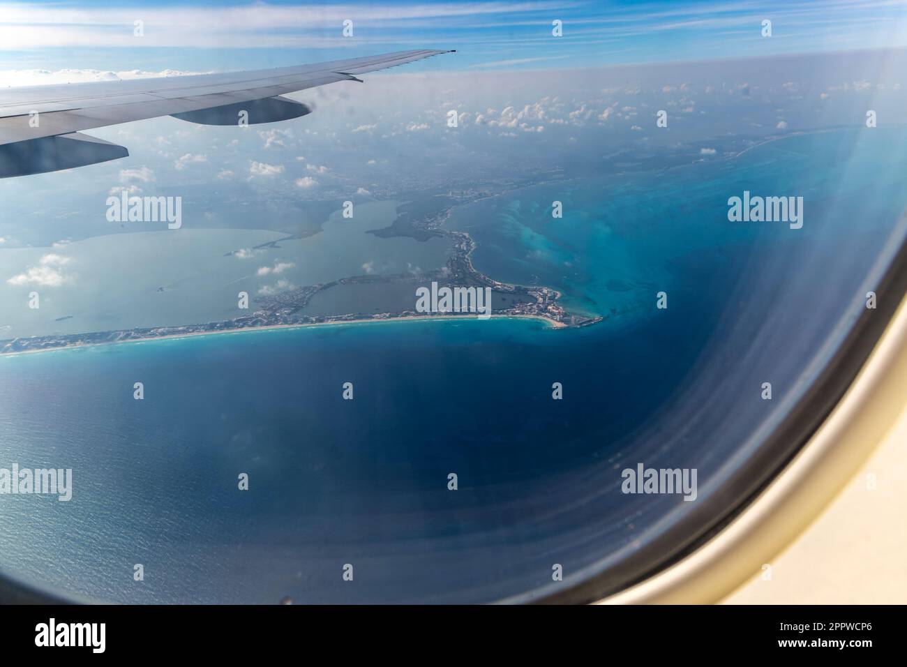 Aerial view through plane window of Caribbean coastline buildings in ...