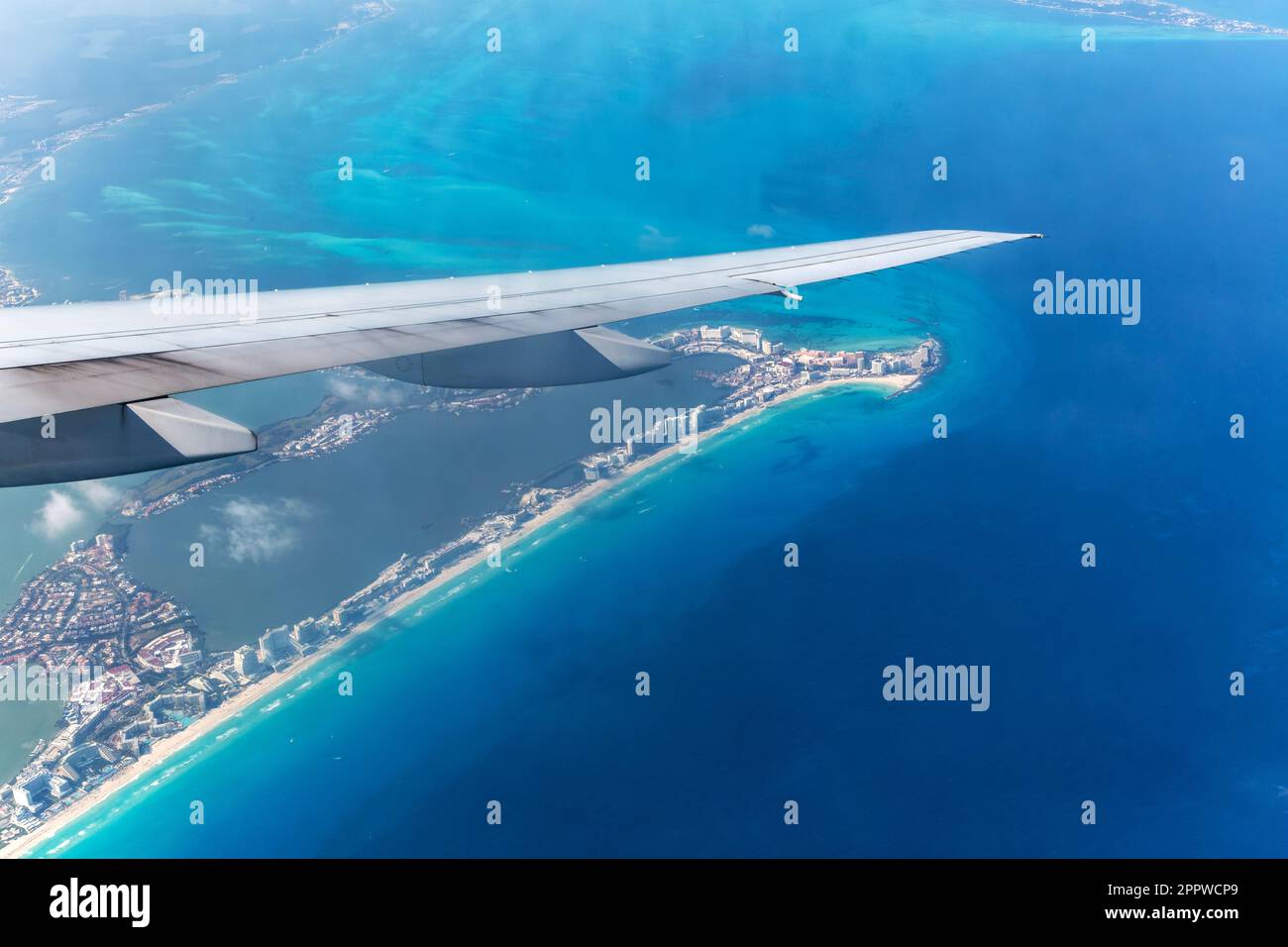 Aerial view through plane window of Caribbean coastline buildings in ...